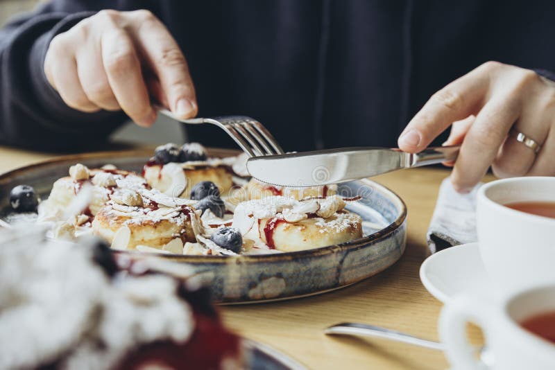 A Man Eats Cheesecakes in a Cafe for Breakfast, a Traditional Ukrainian ...