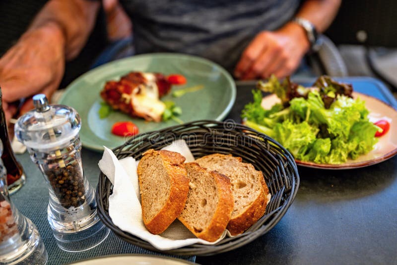 Man Eats in Restaurant, on Table is Bread with Napkin in Wicker, Salad ...