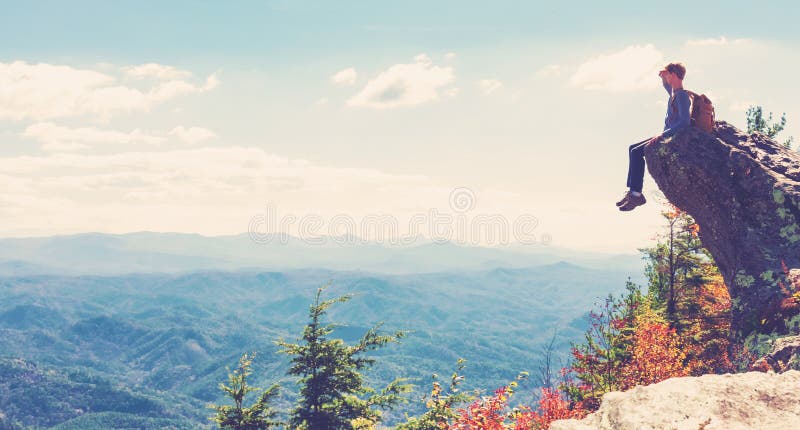 Man Sitting on the Edge of a Cliff Overlooking Stock Photo - Image of ...