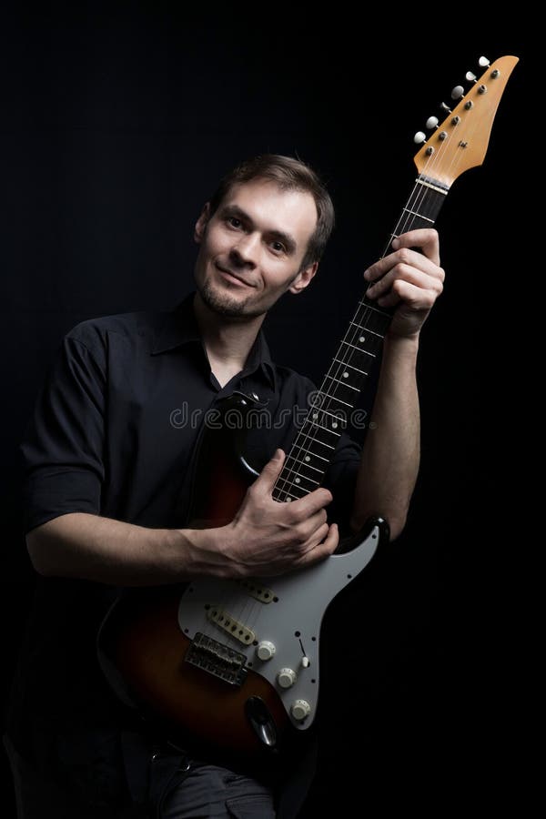 A Man with an Electric Guitar Looks at the Camera Stock Photo - Image ...