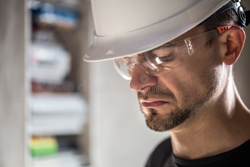 Man, an Electrical Technician Working in a Switchboard with Fuses ...
