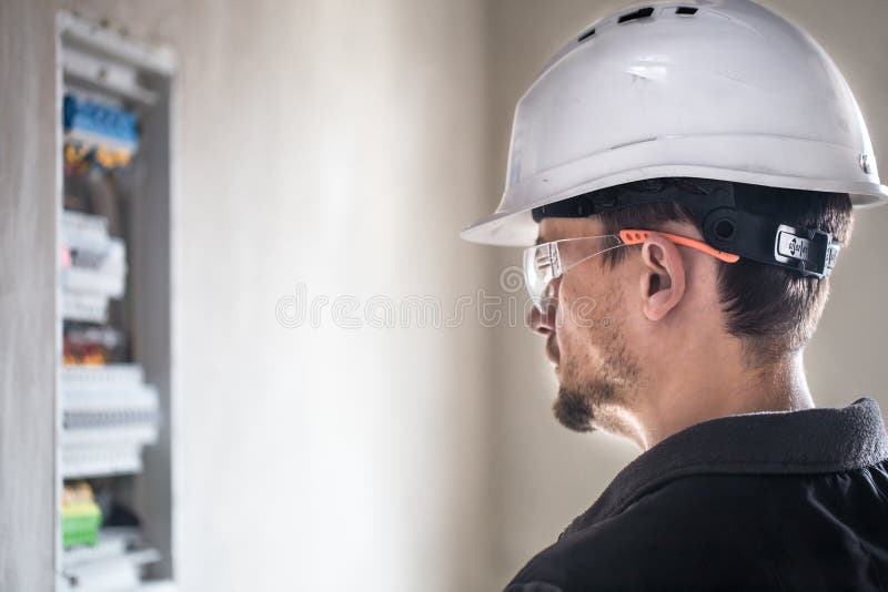 Man, an Electrical Technician Working in a Switchboard with Fuses ...