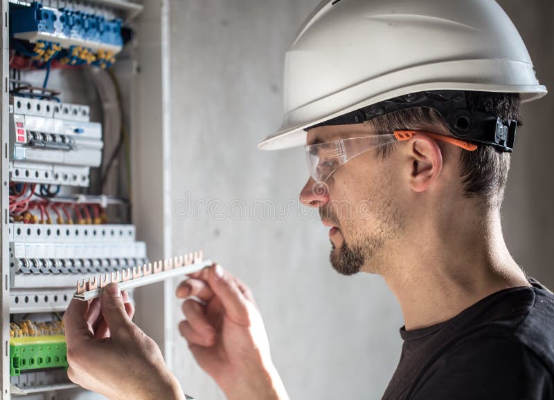 Man, an Electrical Technician Working in a Switchboard with Fuses ...