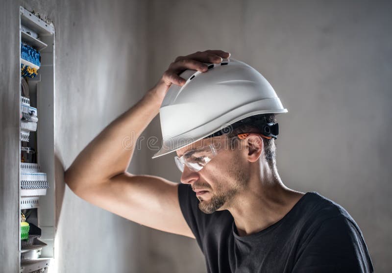 Man, an Electrical Technician Working in a Switchboard with Fuses ...