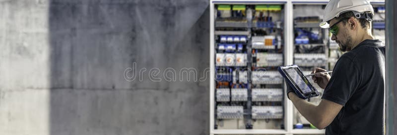 Man, an Electrical Technician Working in a Switchboard with Fuses ...