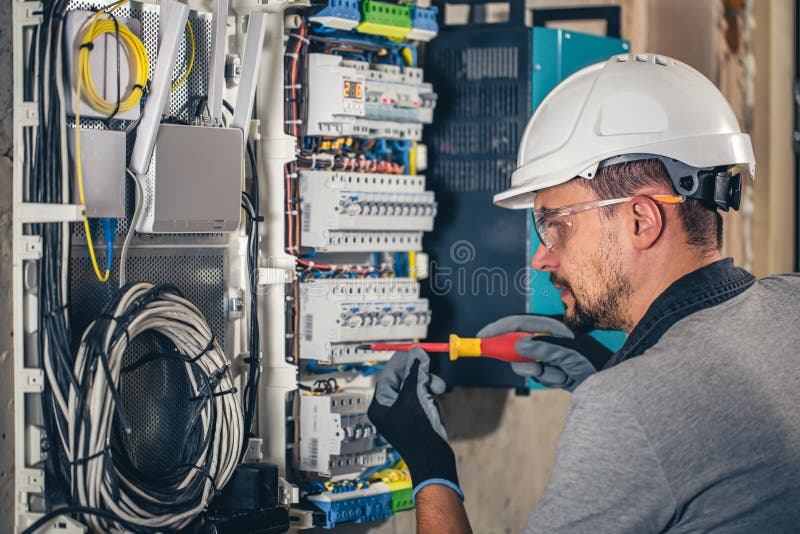 Electrical Technician Working in a Switchboard at Control Panel ...