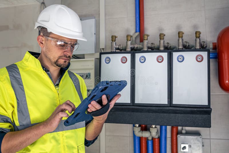 Man, an Electrical Technician Working in a Switchboard with Fuses, Uses ...