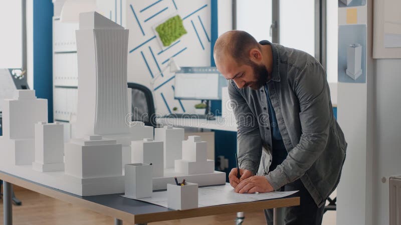 Man Engineer Analyzing Building Model To Design Blueprints Plans on ...