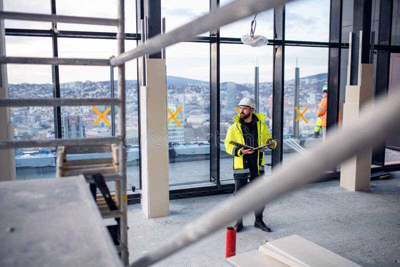 Man Engineer Standing on Construction Site, Holding Blueprints. Stock ...