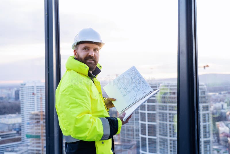 Man Engineer Standing on Construction Site, Holding Blueprints. Stock ...