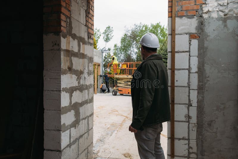 Man Engineer Standing on Construction Site Looking on Workers Stock ...