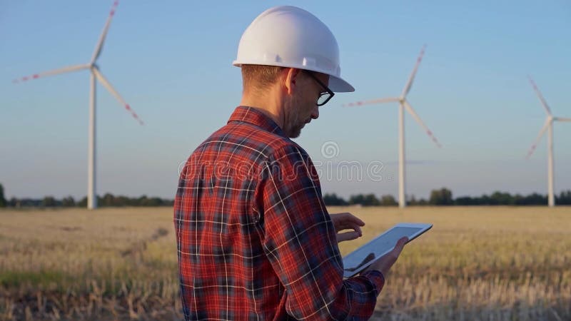 Man Engineer at Work is Taking Notes with a Tablet Computer in a Field ...