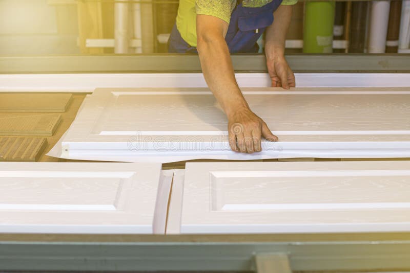 A Man Engineer Working on a Machine for Sticking a Film on an MDF Panel ...
