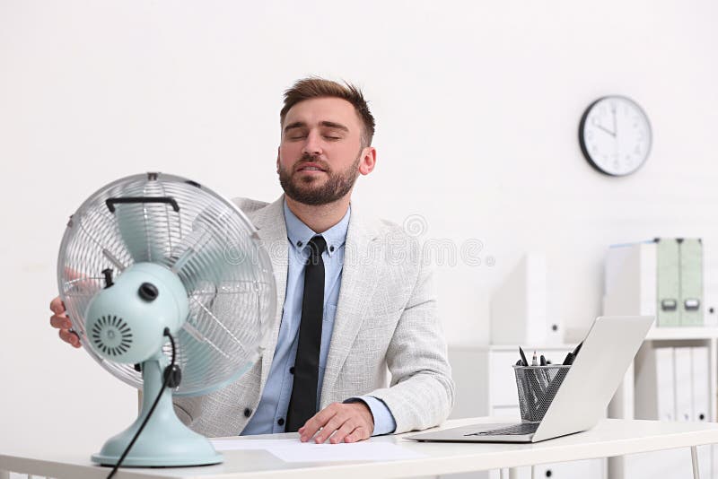 Man Enjoying Air Flow from Fan at Workplace Stock Photo - Image of ...