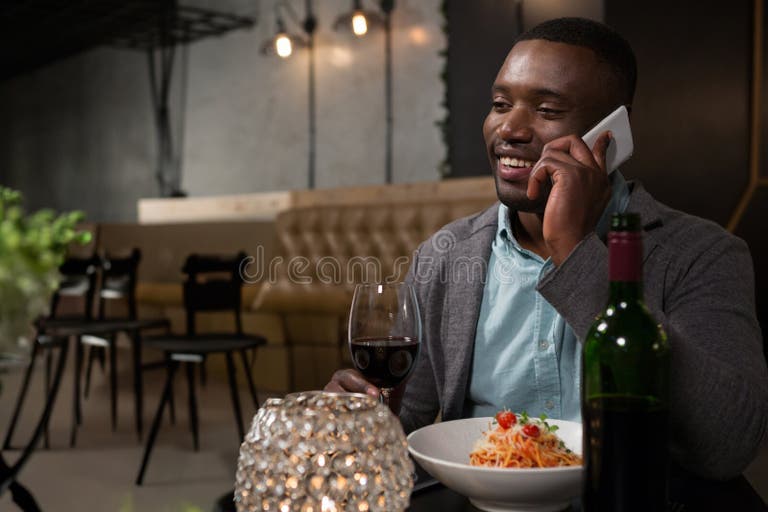 Man Enjoying Dinner while Talking on Smartphone at Elegant Restaurant ...