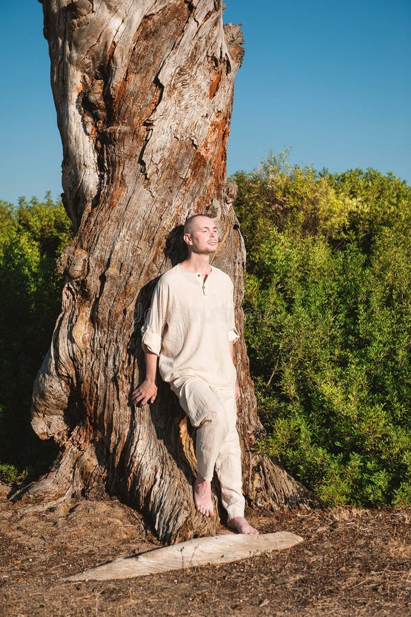 Man Enjoys Meditation Under a Tree, Barefoot and Serene Stock Image ...