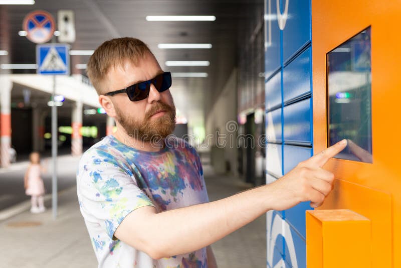Man Enters Parcel Code on Screen and Picks Up Parcel from Automated ...