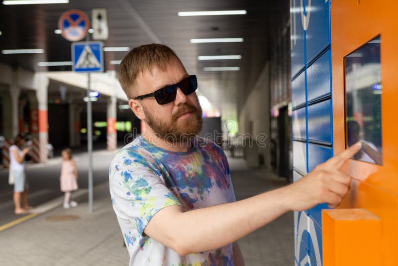 Man Enters Parcel Code on Screen and Picks Up Parcel from Automated ...