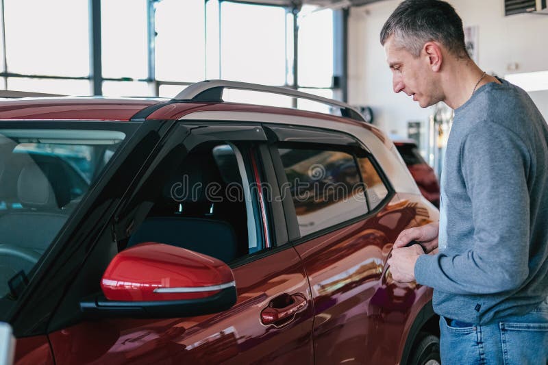 A Man Examines a Car in the Cabin for Defects. Car Rent Stock Image ...