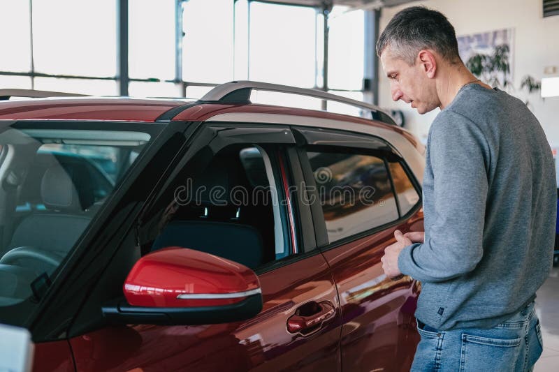 A Man Examines a Car in the Cabin for Defects. Car Rent Stock Image ...