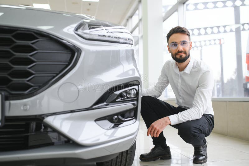 A Man Examines a Car in a Car Dealership Stock Photo - Image of smiling ...
