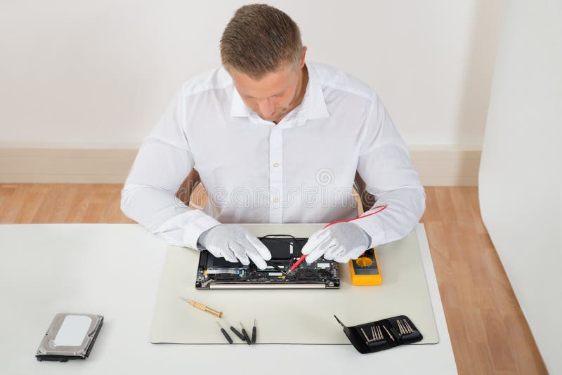 Man Examining Motherboard with Multimeter Stock Photo - Image of ...
