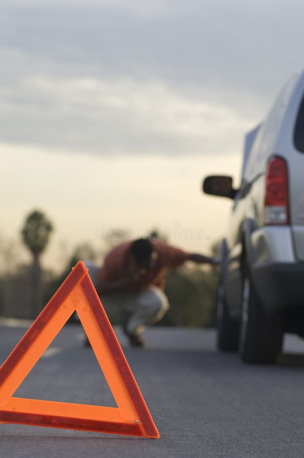 Man Examining the Puncture of Car Stock Photo - Image of caution ...