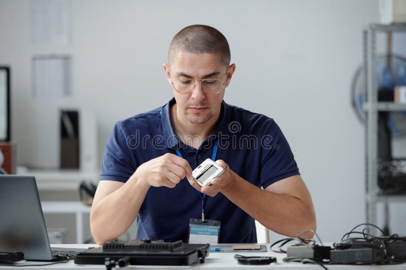 Man Examining Technical Device at His Desk Stock Photo - Image of work ...