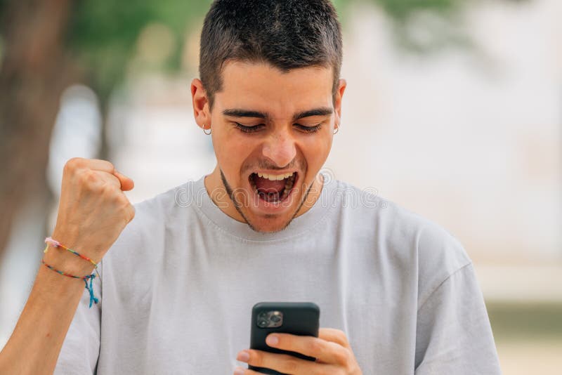Man Excited with Joy Looking at the Mobile Phone Stock Photo - Image of ...