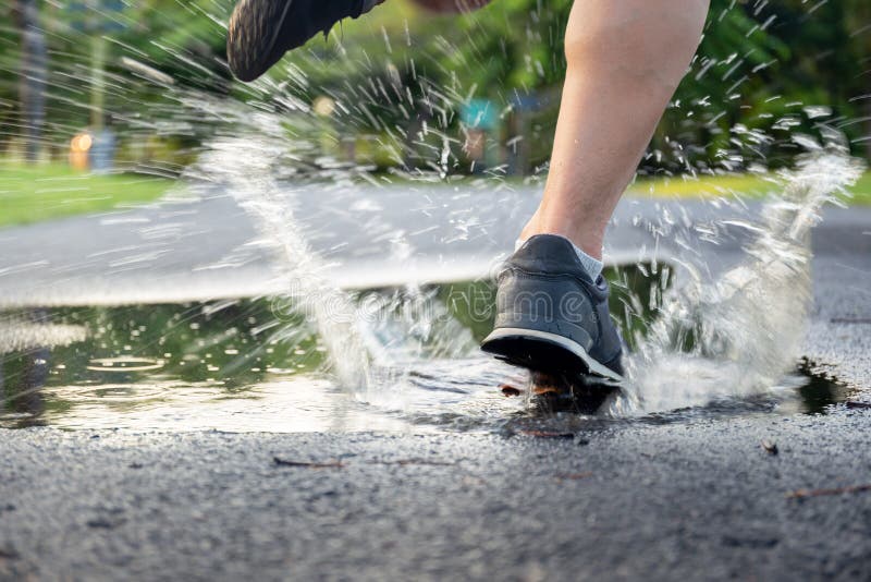 Man Exercise Running through Puddle Splashing His Shoes. Stock Photo ...