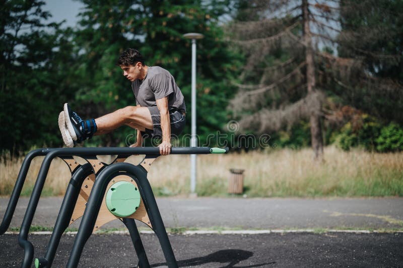 Man Exercising Abs on Parallel Bars in a Park during a Workout Session ...