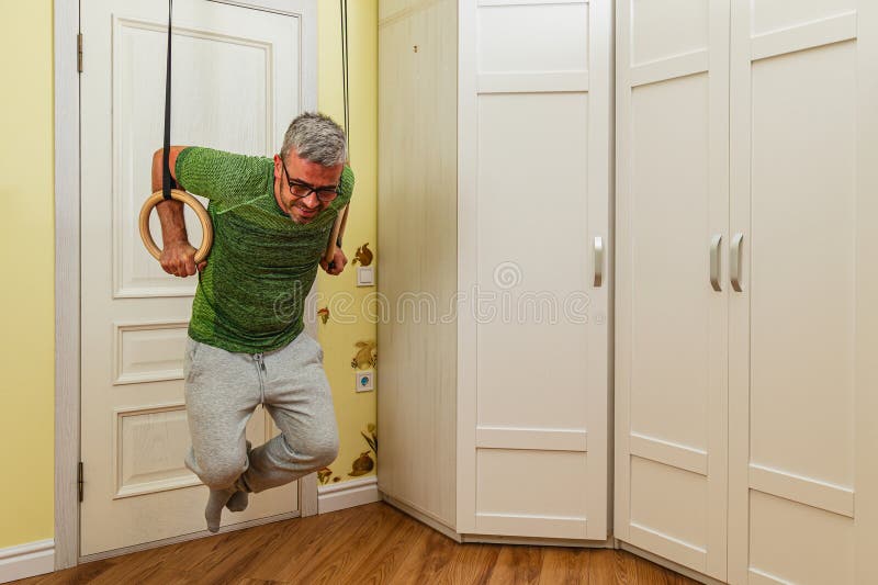 Man Exercising with Gymnastic Rings at Home Stock Photo - Image of ...