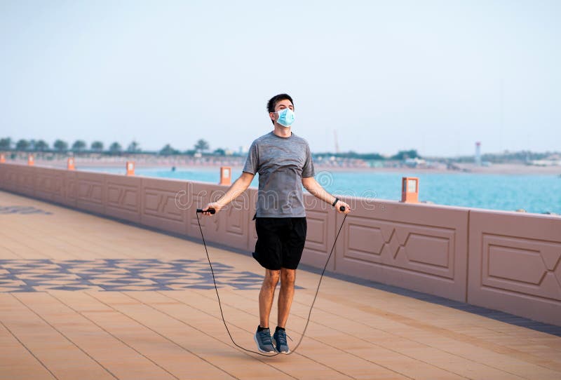 Man Exercising with a Jumping Rope and Wearing Protective Surgical Mask ...