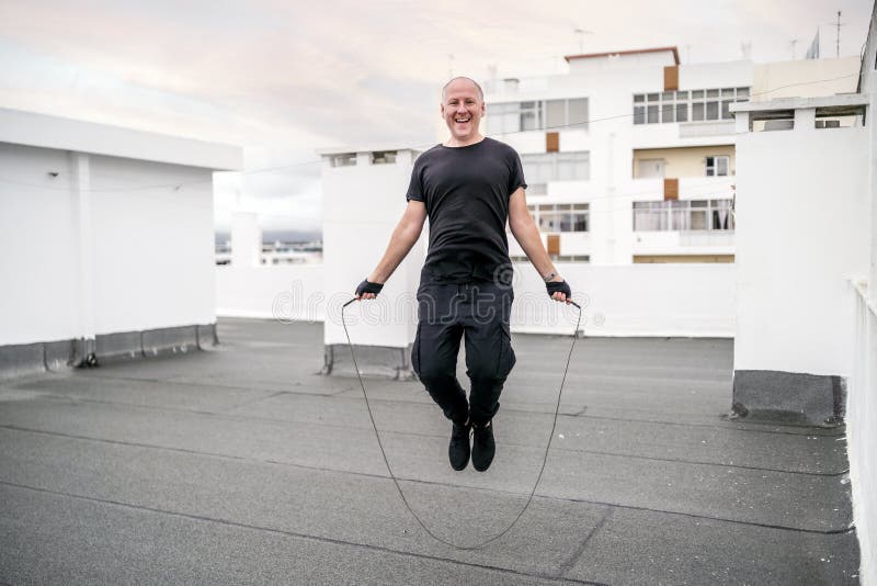 A Man Exercising on the Rooftop Using Jumping Rope during the Lockdown ...
