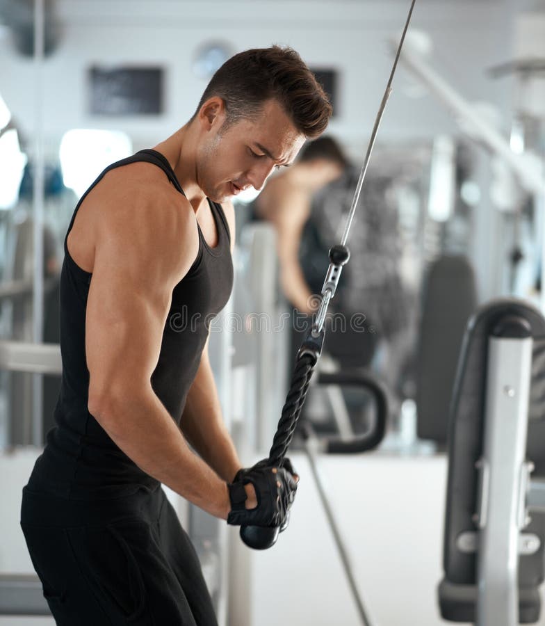 Handsome Blond Young Man Exercising Triceps on Gym Equipment Stock ...