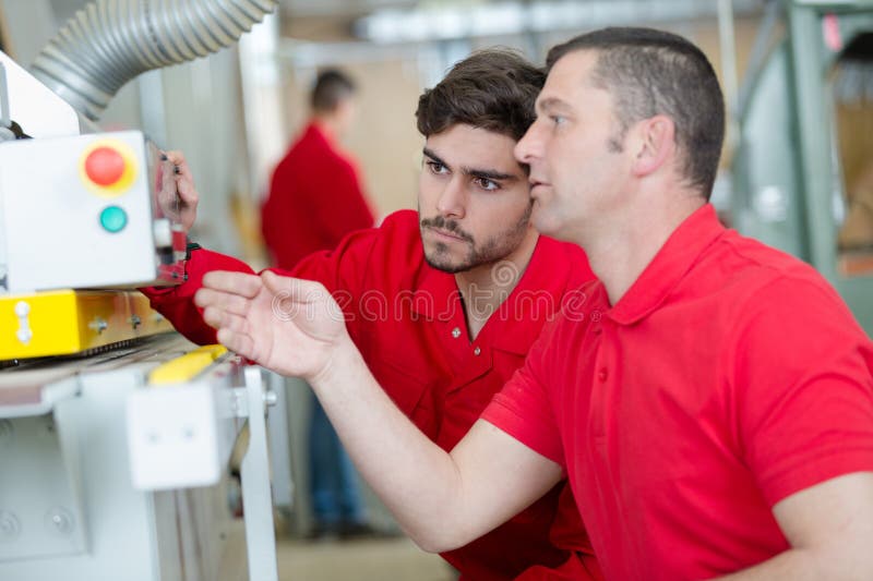 Man Explaining Controls Industrial Machine To Younger Worker Stock ...