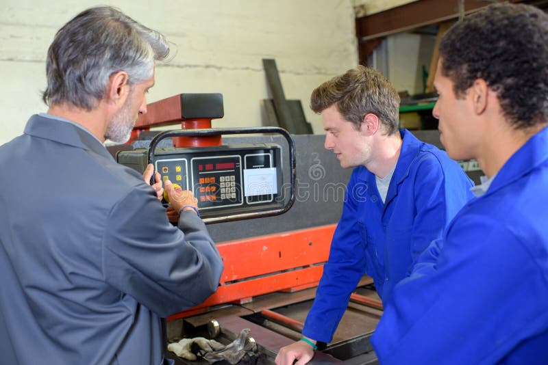 Man Explaining Workings Machine To Two Students Stock Image - Image of ...