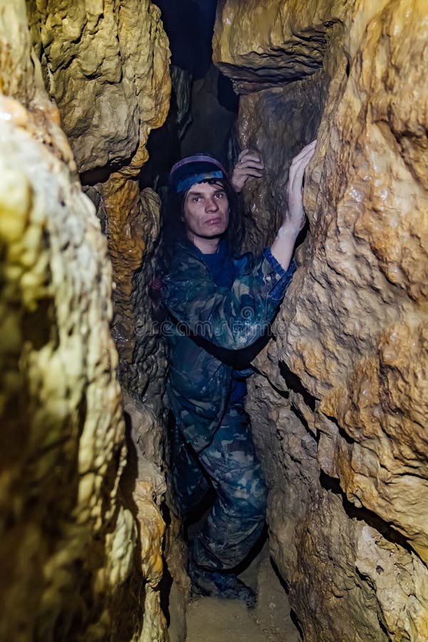 Man explores narrow cave stock image. Image of geology - 140376637