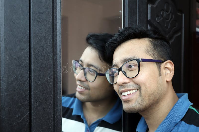 A Man in Eye Glasses and His Reflection in Mirror Smiling in Happy Mood ...