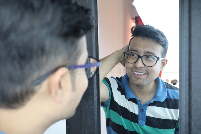 A Man with Eyeglass Looking at His Reflection in Mirror and Smiling at ...