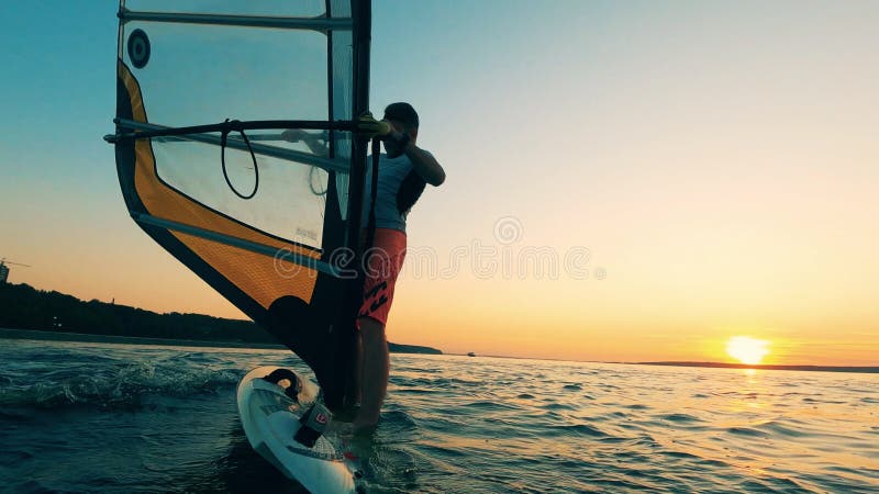A Man is Falling from the Windsurf Board and Dropping the Sail Stock ...