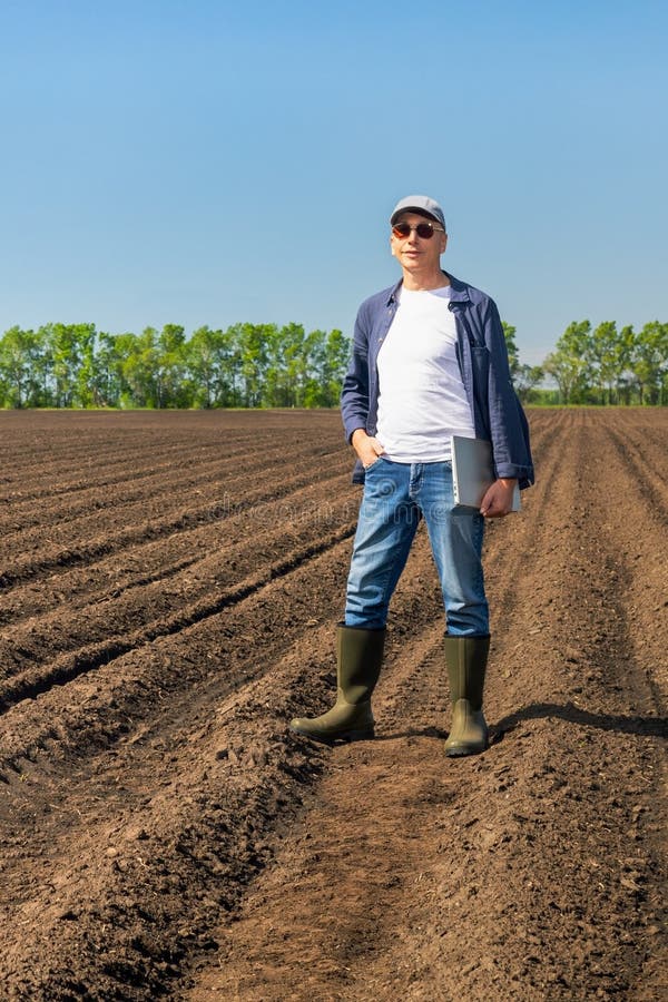 Man Farmer Standing the Field and Using Laptop, Tablet Computer. Stock ...