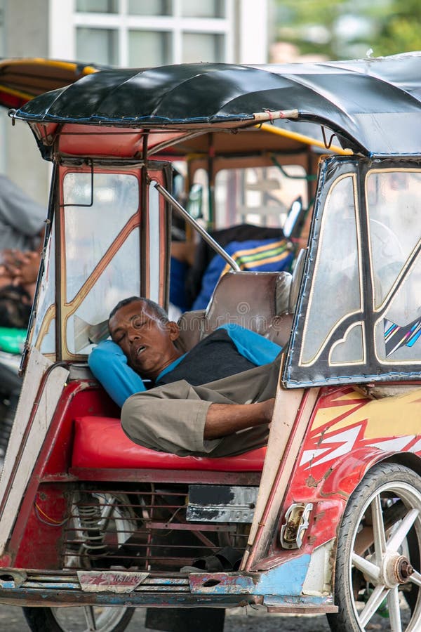 A Man is Fast Asleep on His Motorized Rickshaw ( Bentor). Editorial ...