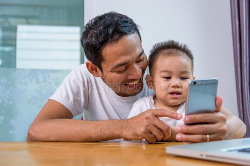Man Father Working on Laptop Computer and Using Smartphone Technology ...