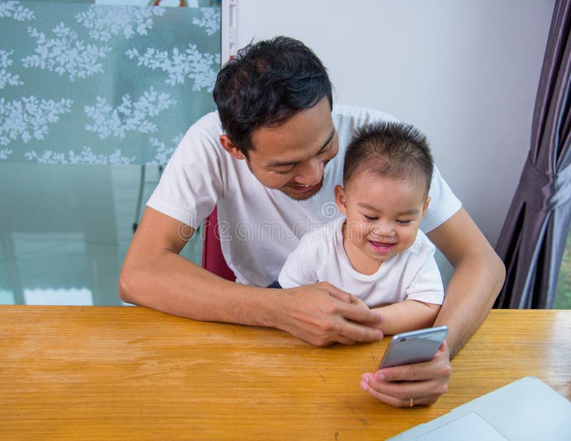 Man Father Working on Laptop Computer and Using Smartphone Technology ...