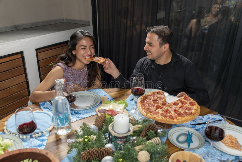 Man Feeding His Partner Pizza in His Mouth during Christmas Dinner ...