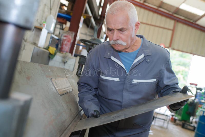 Man Feeding Metal into Machine Stock Image - Image of steel, process ...