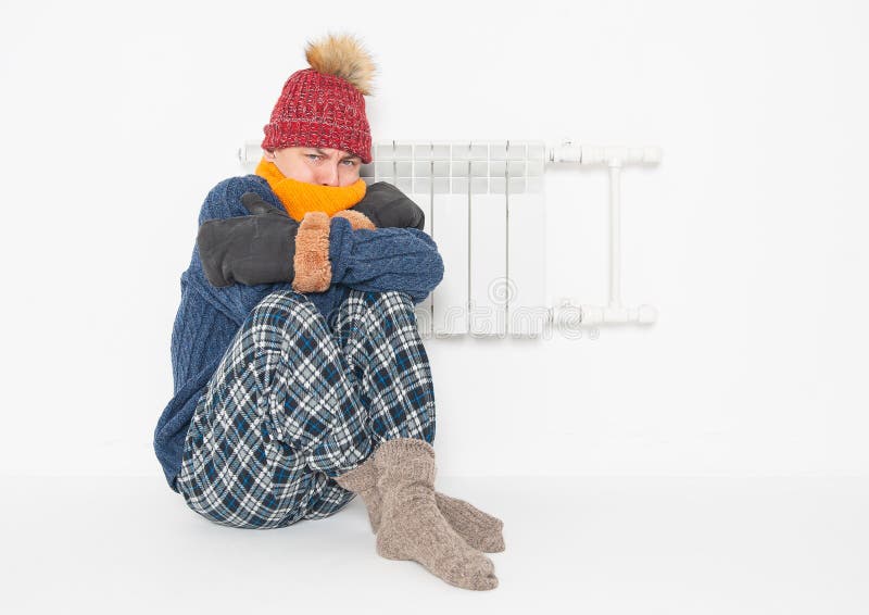 Man Feeling Cold in Hat and Pullover Sitting Close To Radiator. Gas ...
