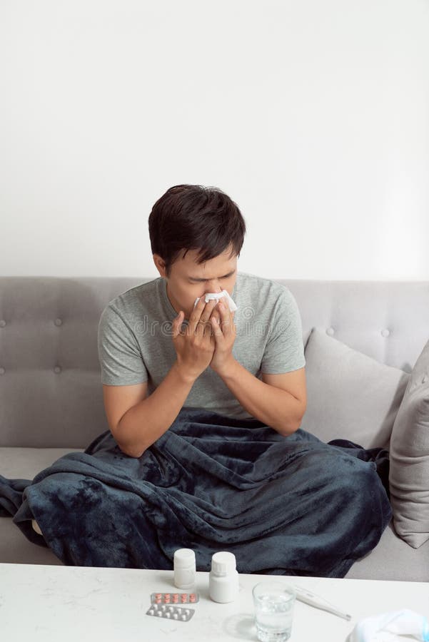 Man Feeling Cold, Lying in the Sofa and Blowing His Nose Stock Photo ...