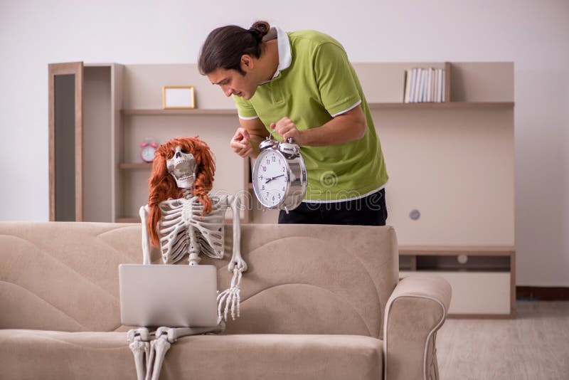 Young Man with Female Skeleton in Time Management Concept Stock Photo ...